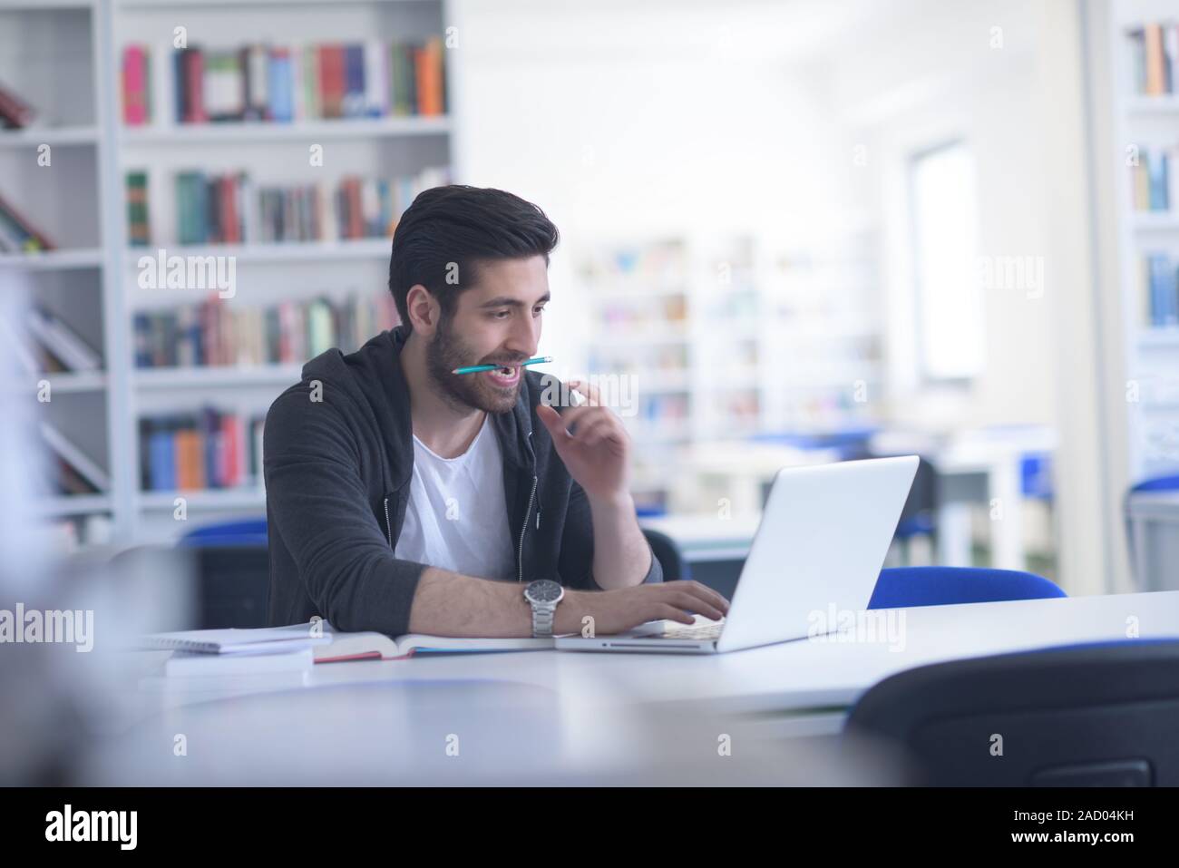 student in school library using laptop for research Stock Photo - Alamy