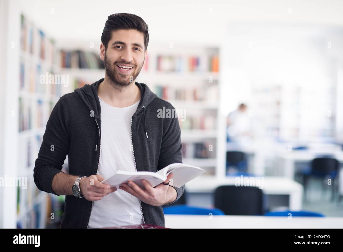 portrait of student while reading book in school library Stock Photo ...