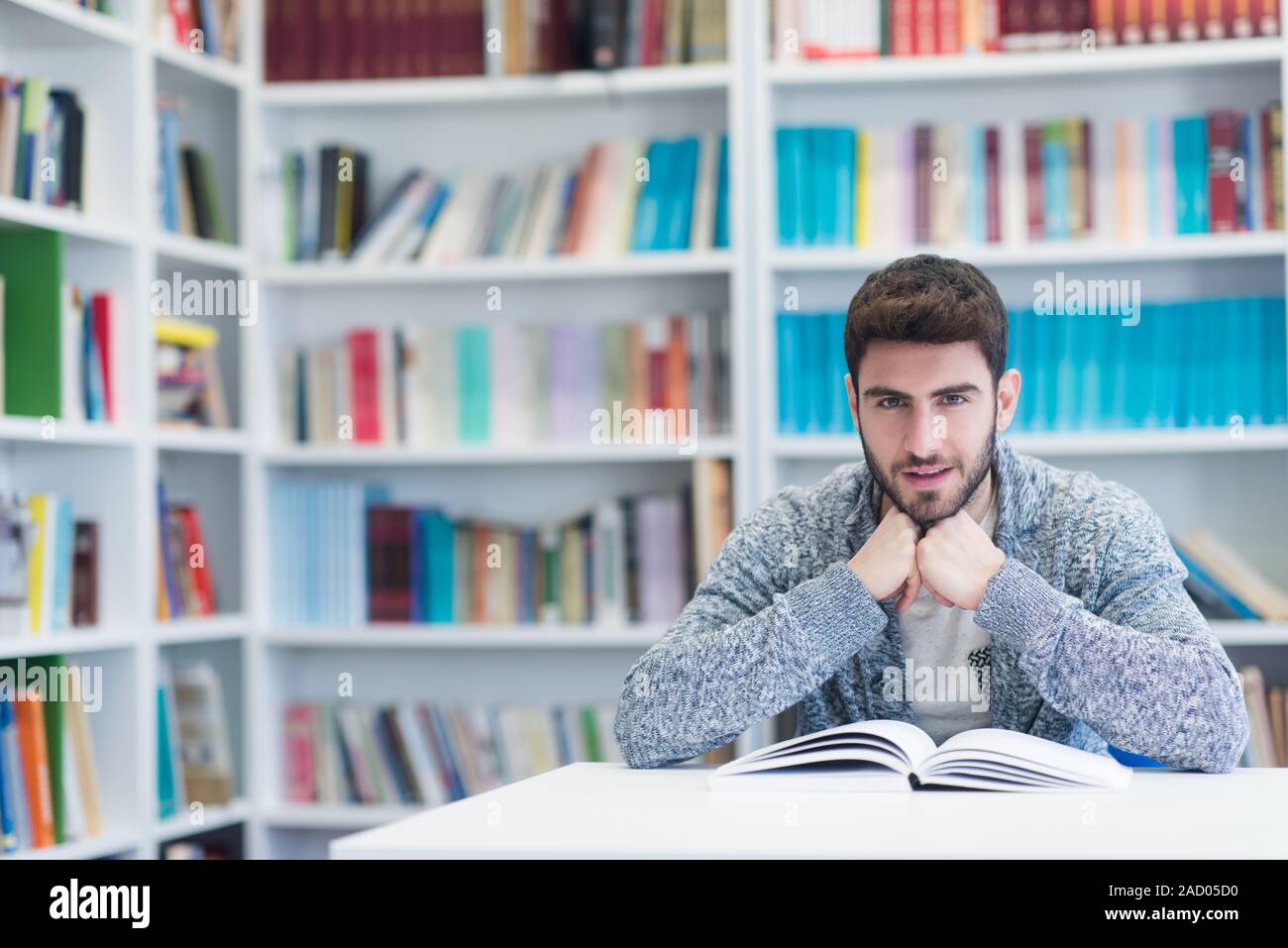 portrait of student while reading book in school library Stock Photo ...
