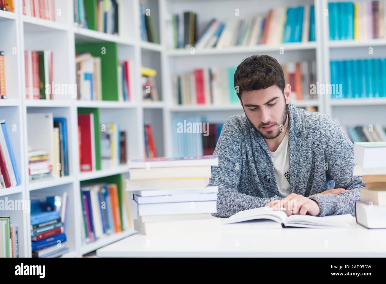 portrait of student while reading book in school library Stock Photo ...