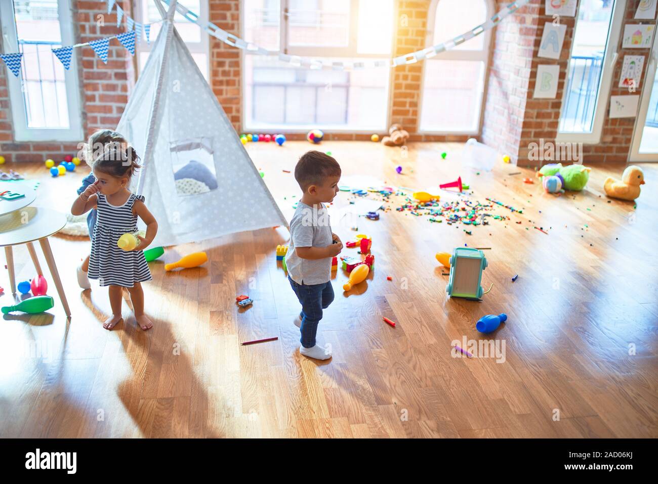 Adorable group of toddlers playing around lots of toys at kindergarten ...