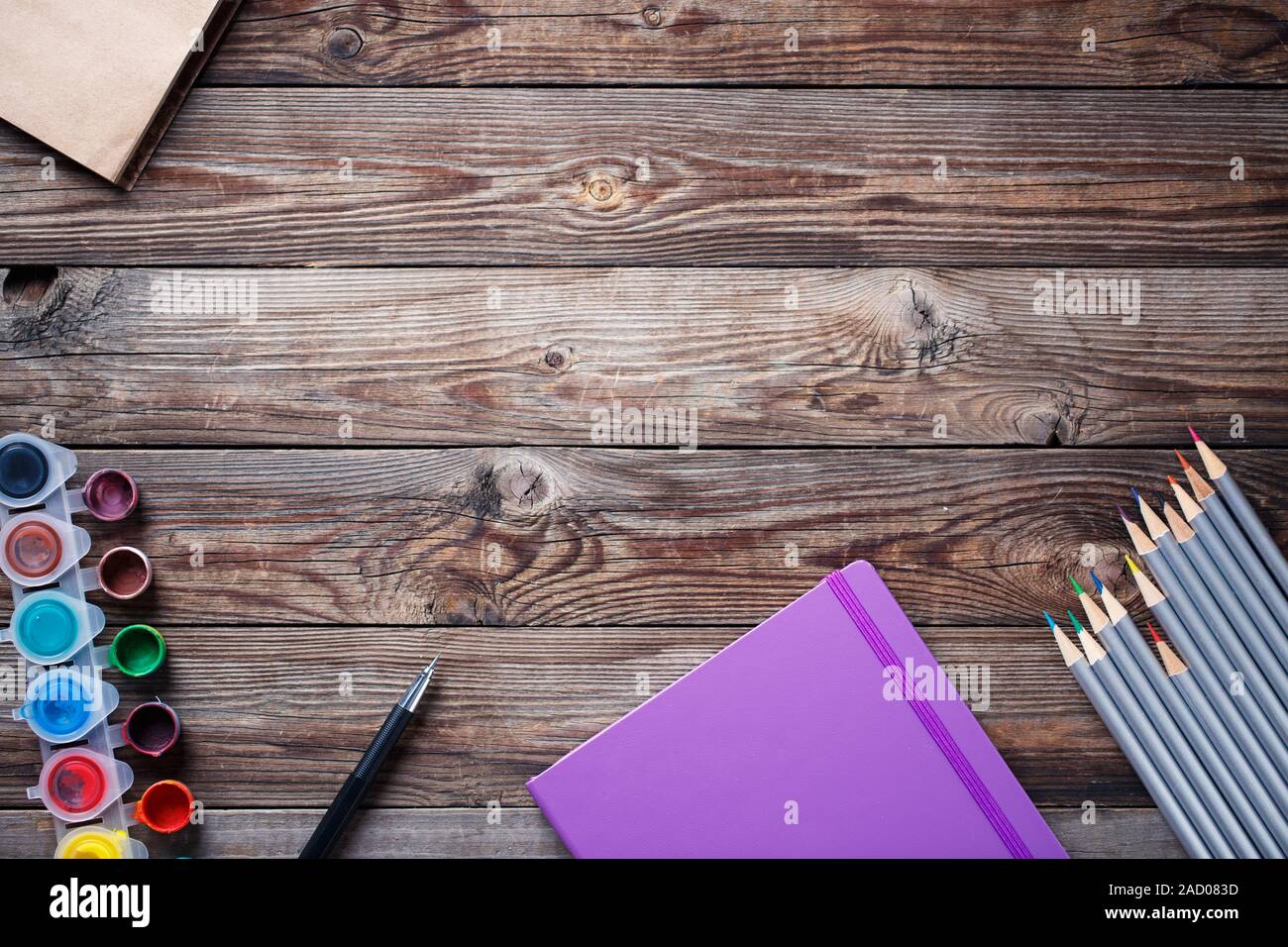 Watercolors, color pencils and sketchbook on wooden table. Flat lay ...