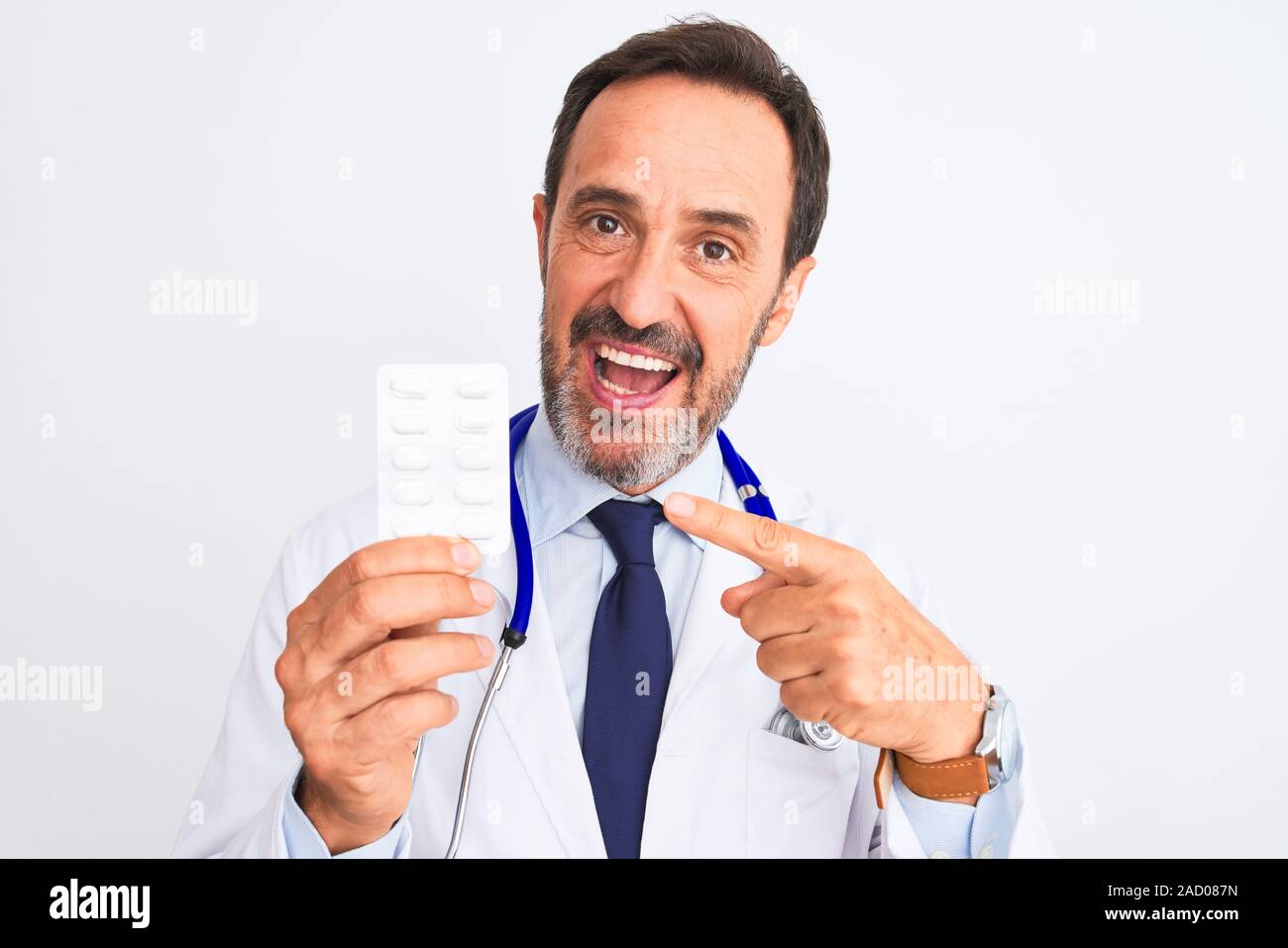 Middle age doctor man holding pills standing over isolated white ...