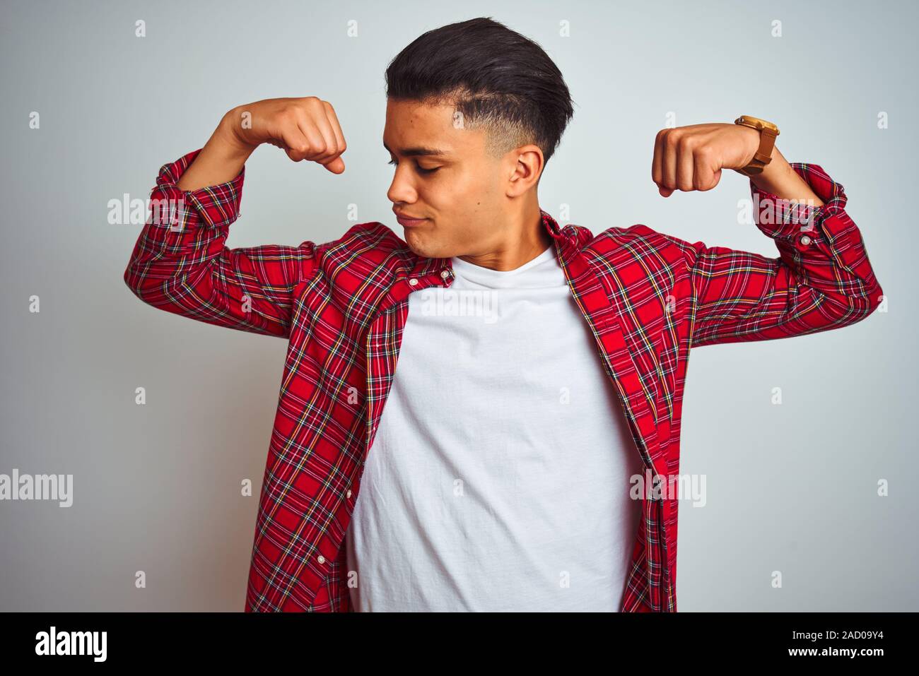 Young brazilian man wearing red shirt standing over isolated white ...