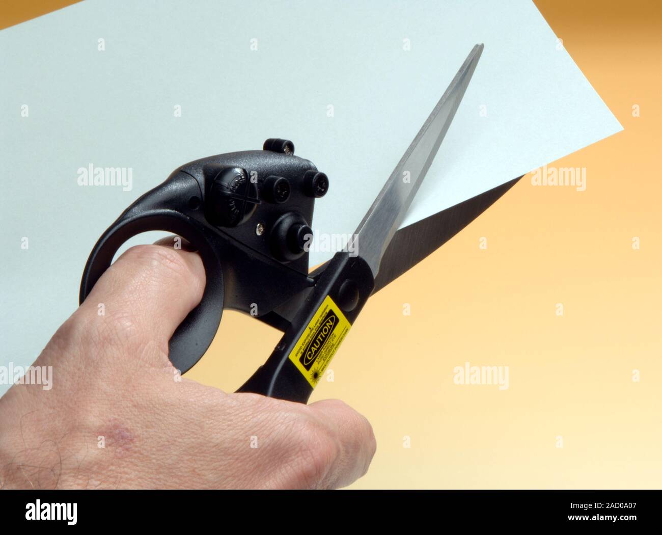 Laser-guided scissors. Person using a pair of scissors that use a built ...