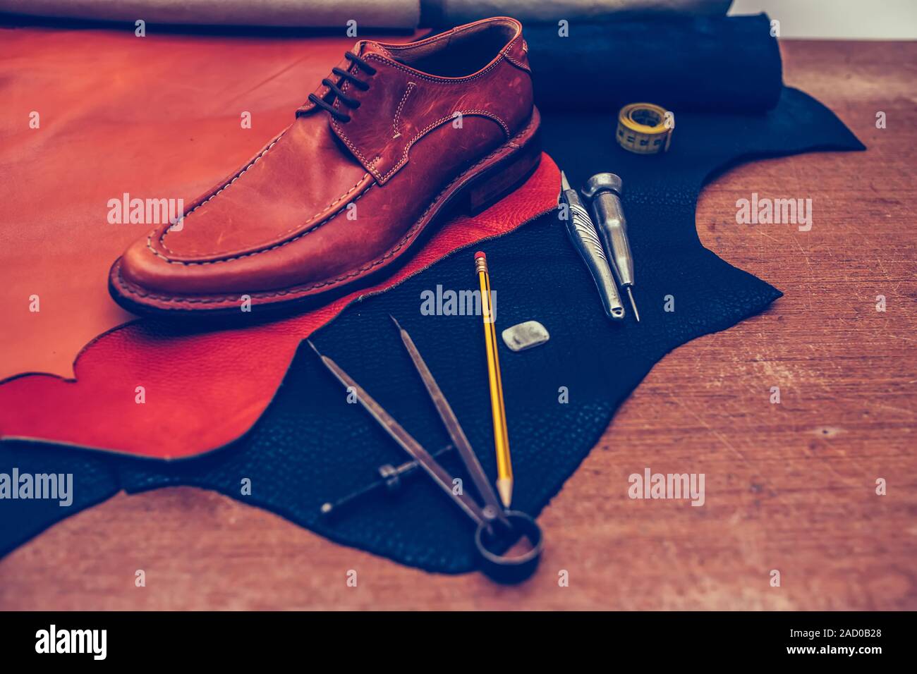 Shoemaker's work desk. Tools and leather at cobbler workplace. Man classic brown shoes and ...