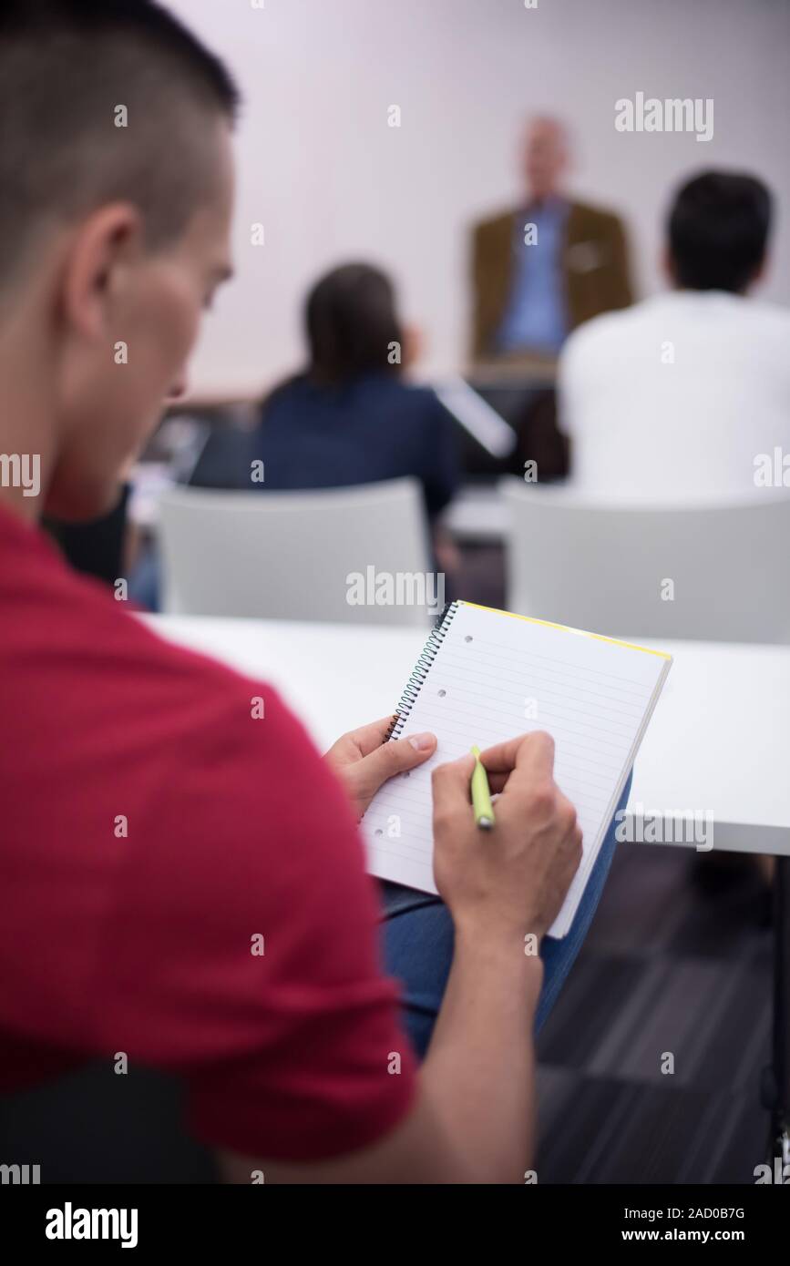 male student taking notes in classroom Stock Photo - Alamy
