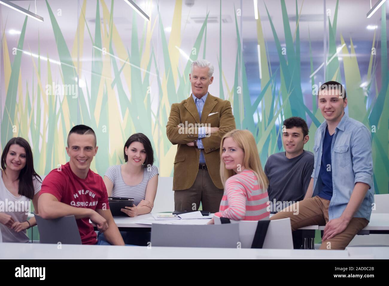 portrait of teacher with students group in background Stock Photo - Alamy