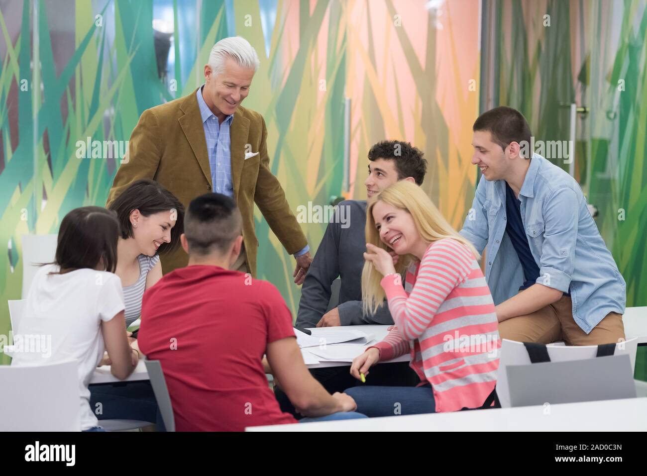 teacher with a group of students in classroom Stock Photo - Alamy