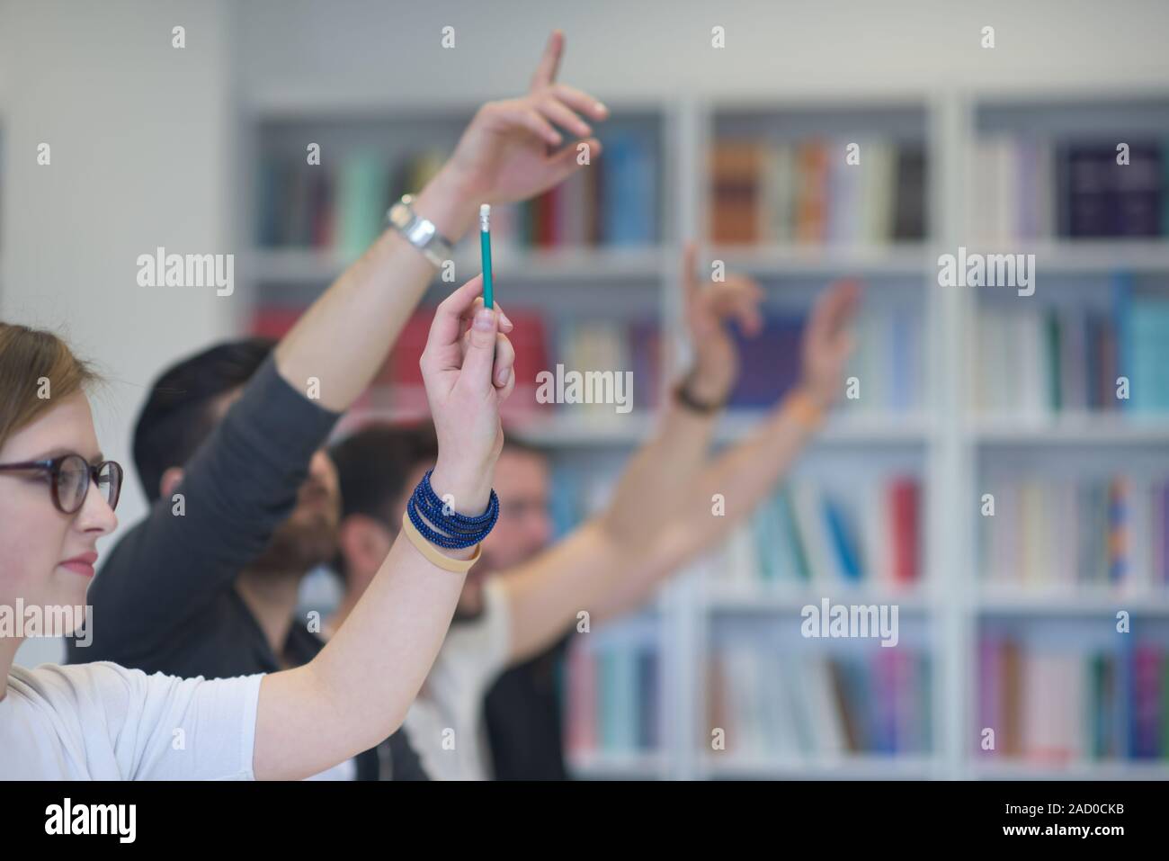 group of students raise hands up Stock Photo - Alamy