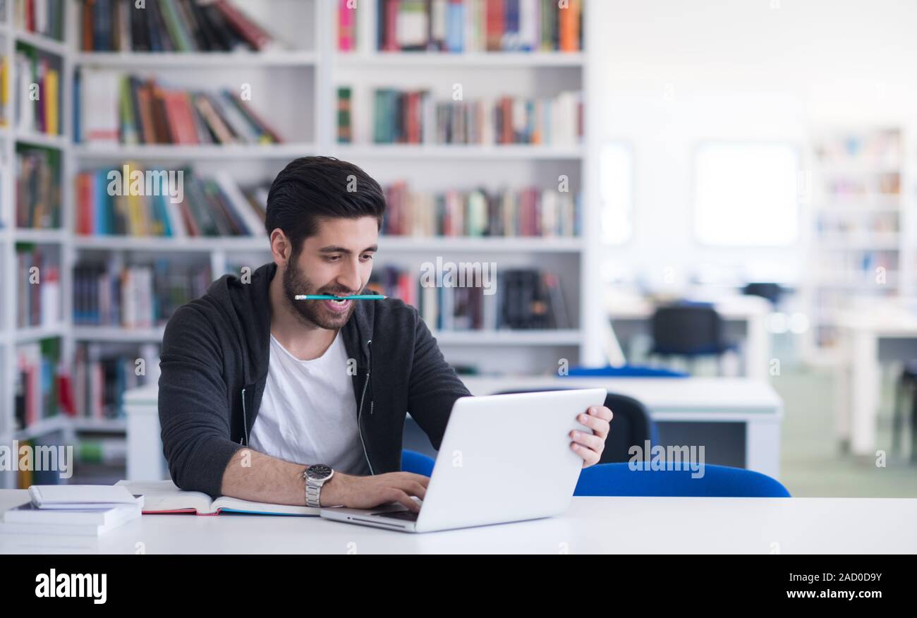 student in school library using laptop for research Stock Photo - Alamy