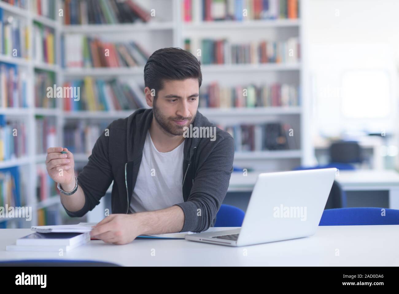student in school library using laptop for research Stock Photo - Alamy