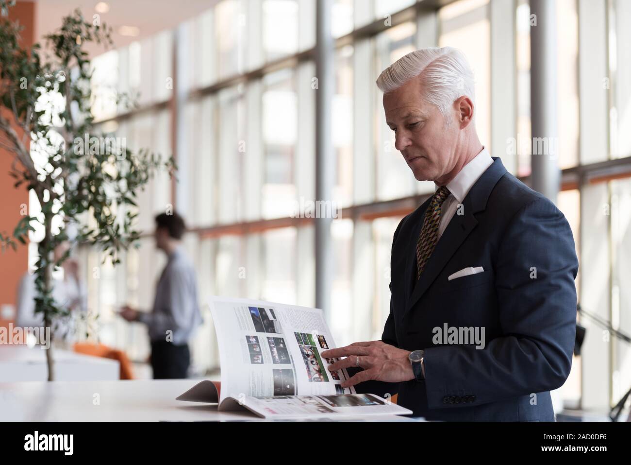 Successful businessman reading magazine hi-res stock photography and ...