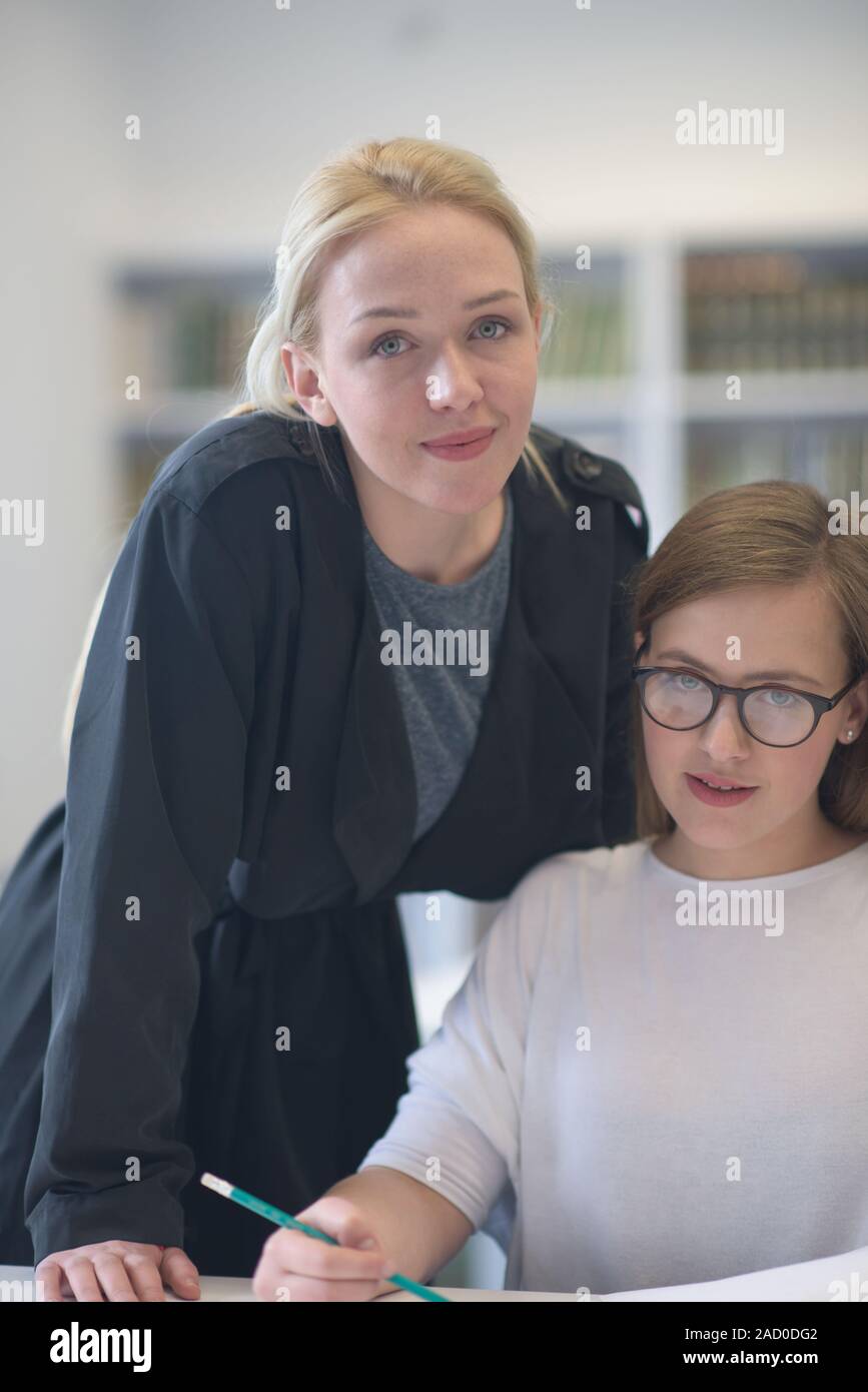 female teacher helping students on class Stock Photo - Alamy