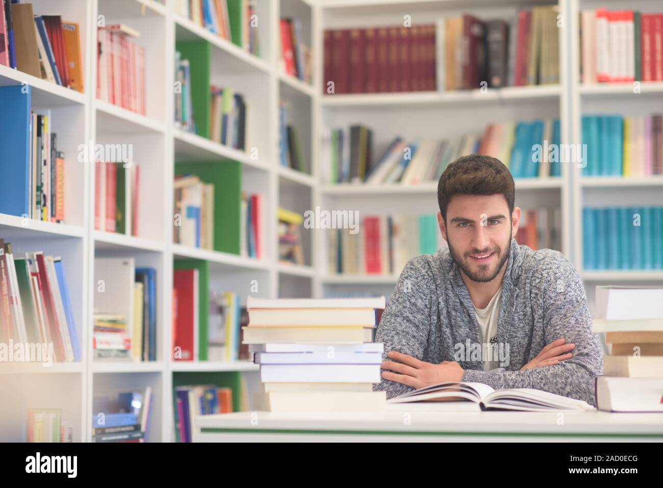 portrait of student while reading book in school library Stock Photo ...