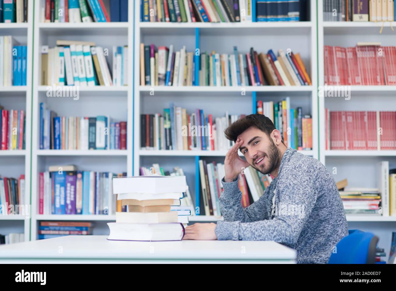 portrait of student while reading book in school library Stock Photo ...