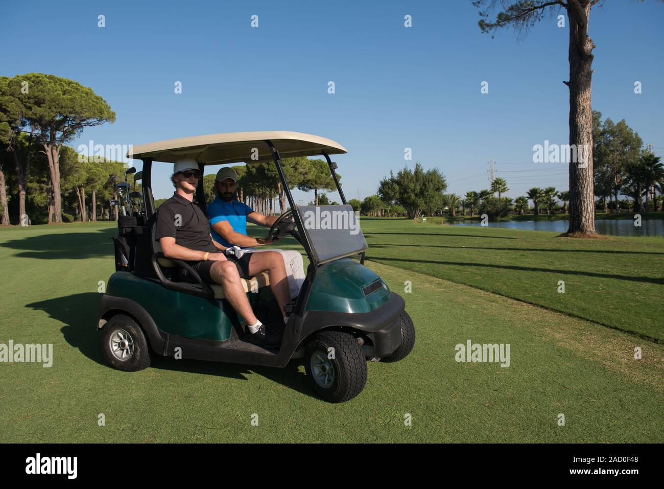 golf players driving cart at course Stock Photo - Alamy
