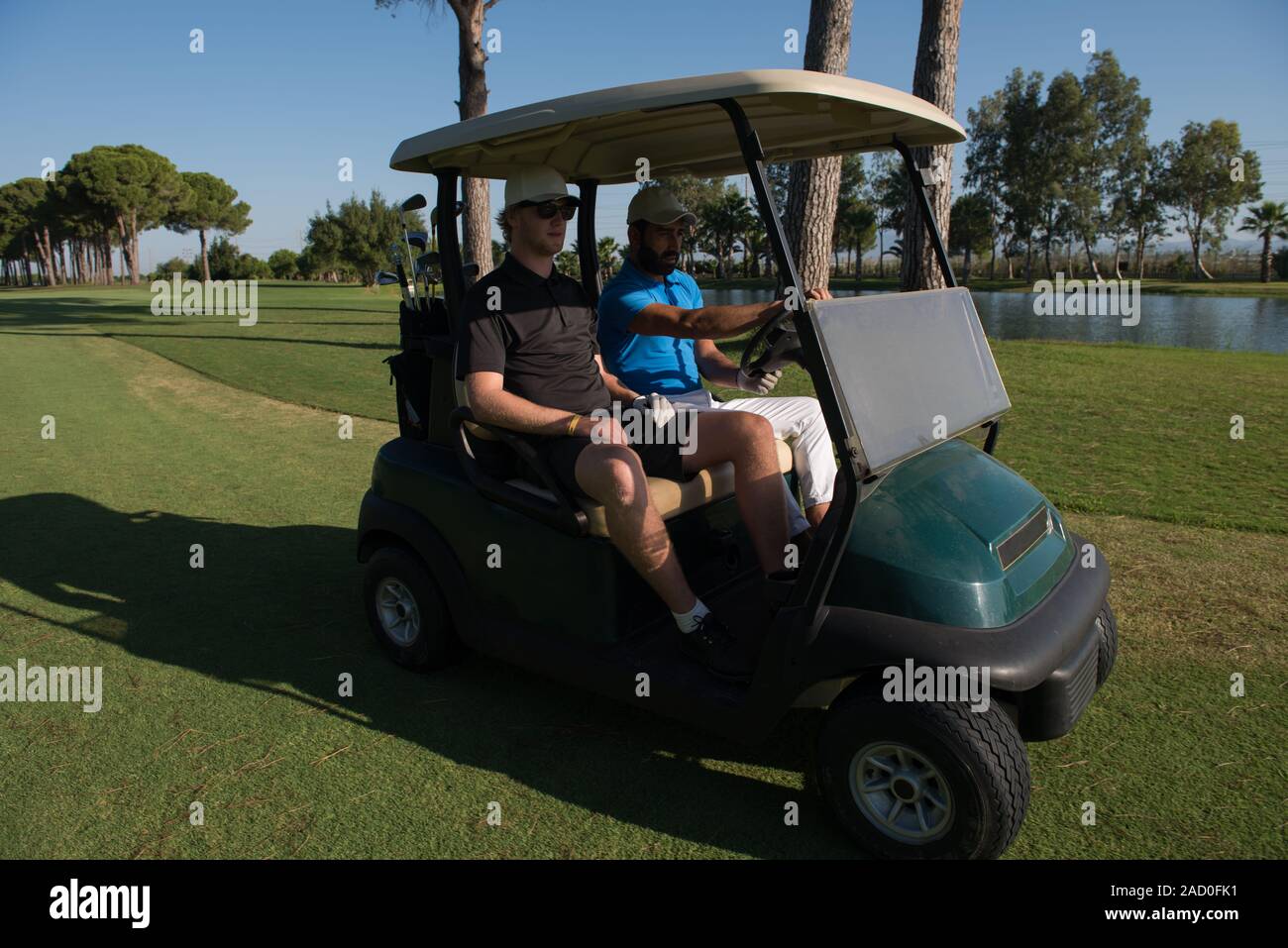 golf players driving cart at course Stock Photo - Alamy
