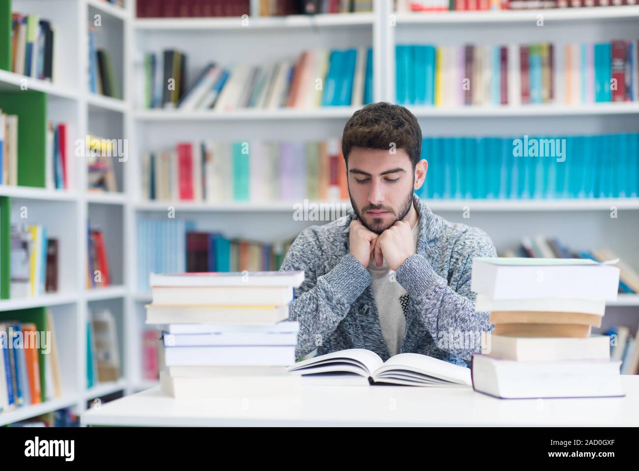 portrait of student while reading book in school library Stock Photo ...