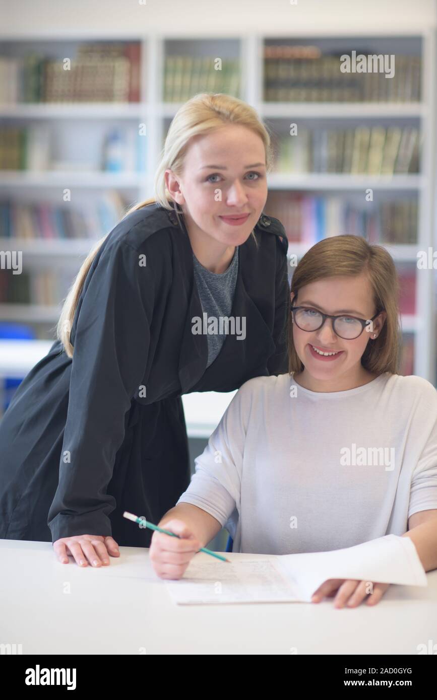 female teacher helping students on class Stock Photo - Alamy