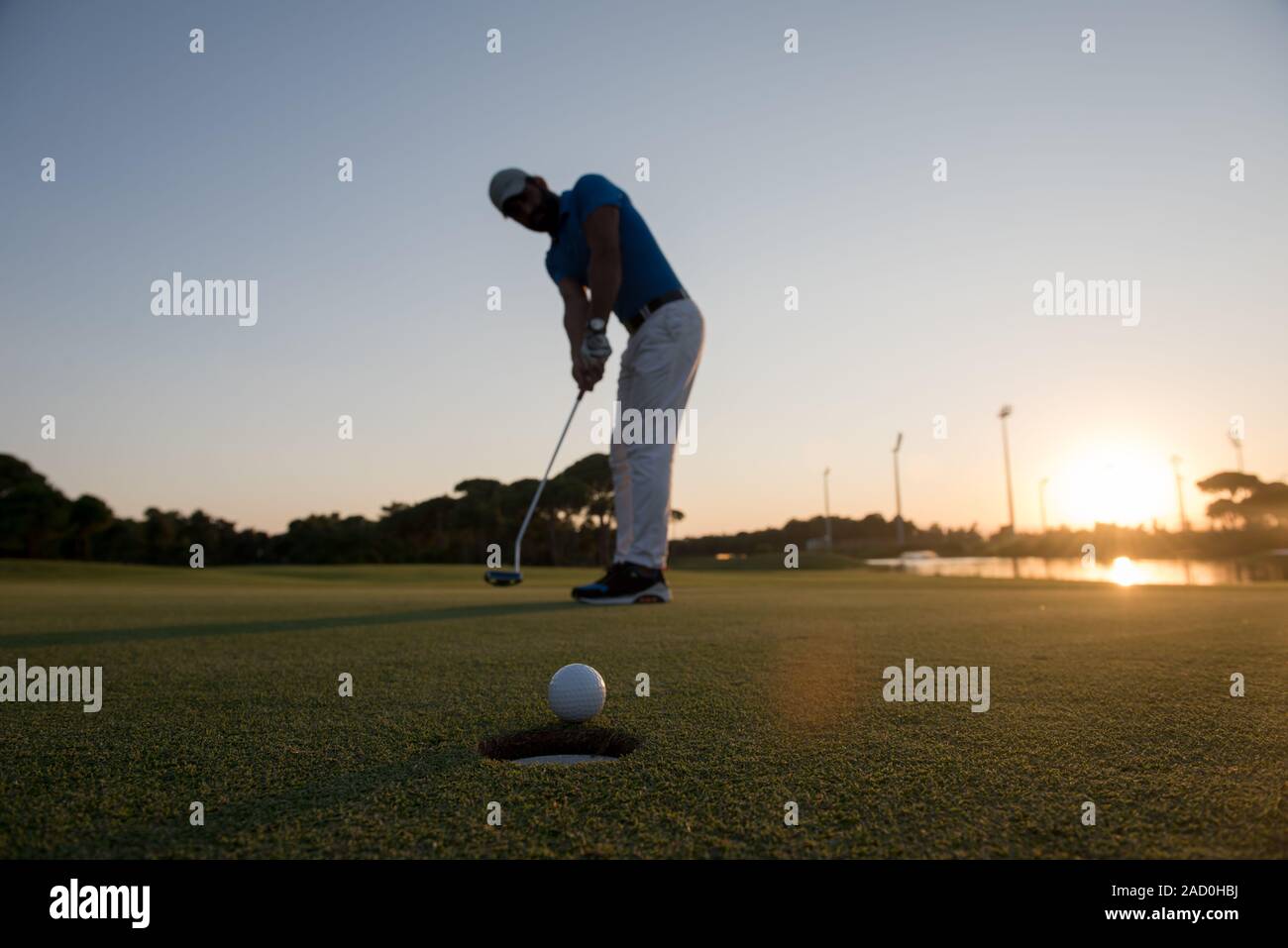 golfer hitting shot at golf course Stock Photo - Alamy
