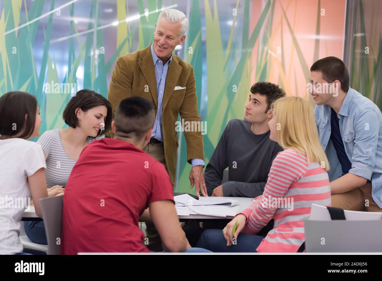 teacher with a group of students in classroom Stock Photo - Alamy