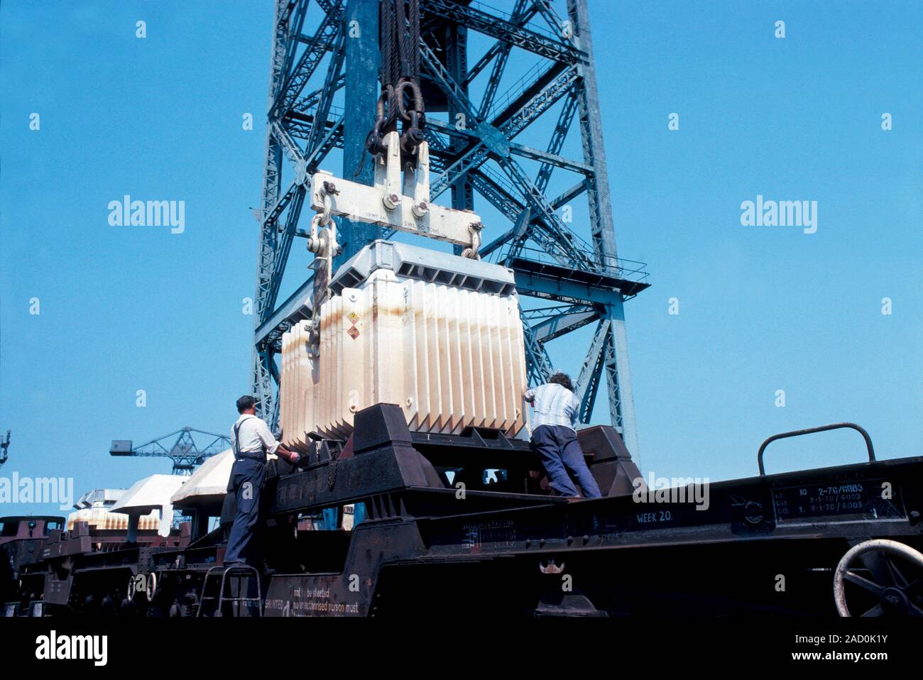 Nuclear waste handling. Workers handling a container that has been ...