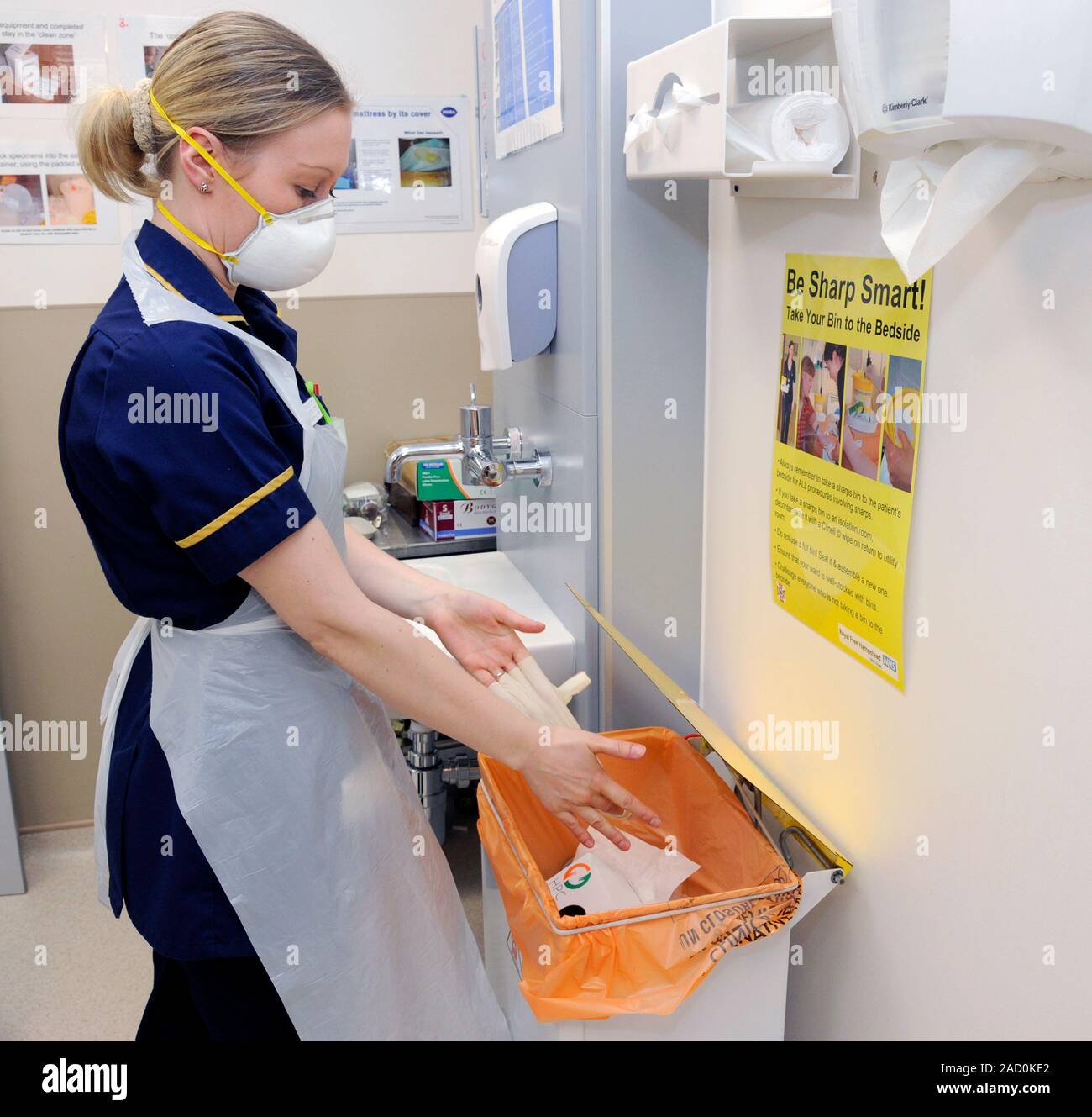 Hospital infection control. Hospital nurse disposing of her infection ...