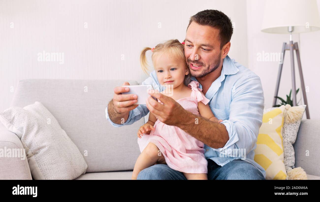 Father watching cartoons with his daughter on phone Stock Photo - Alamy