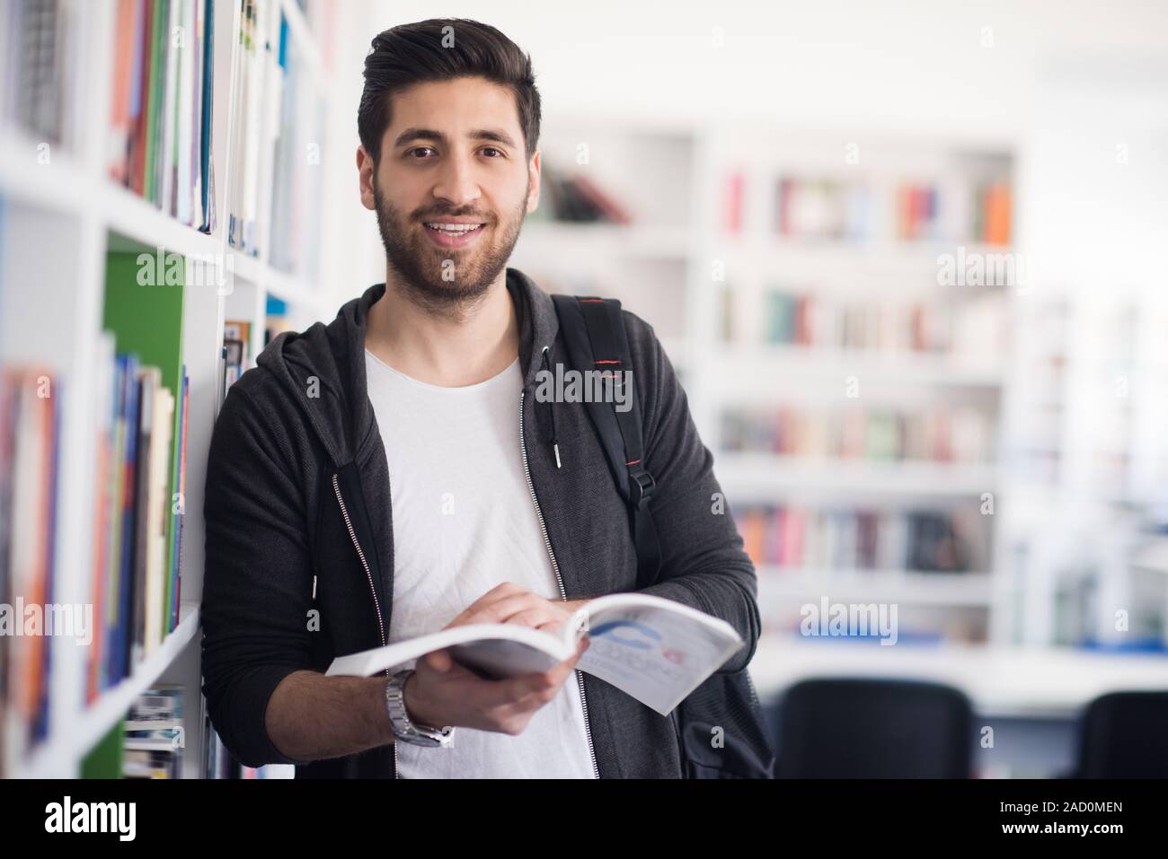 portrait of student while reading book in school library Stock Photo ...