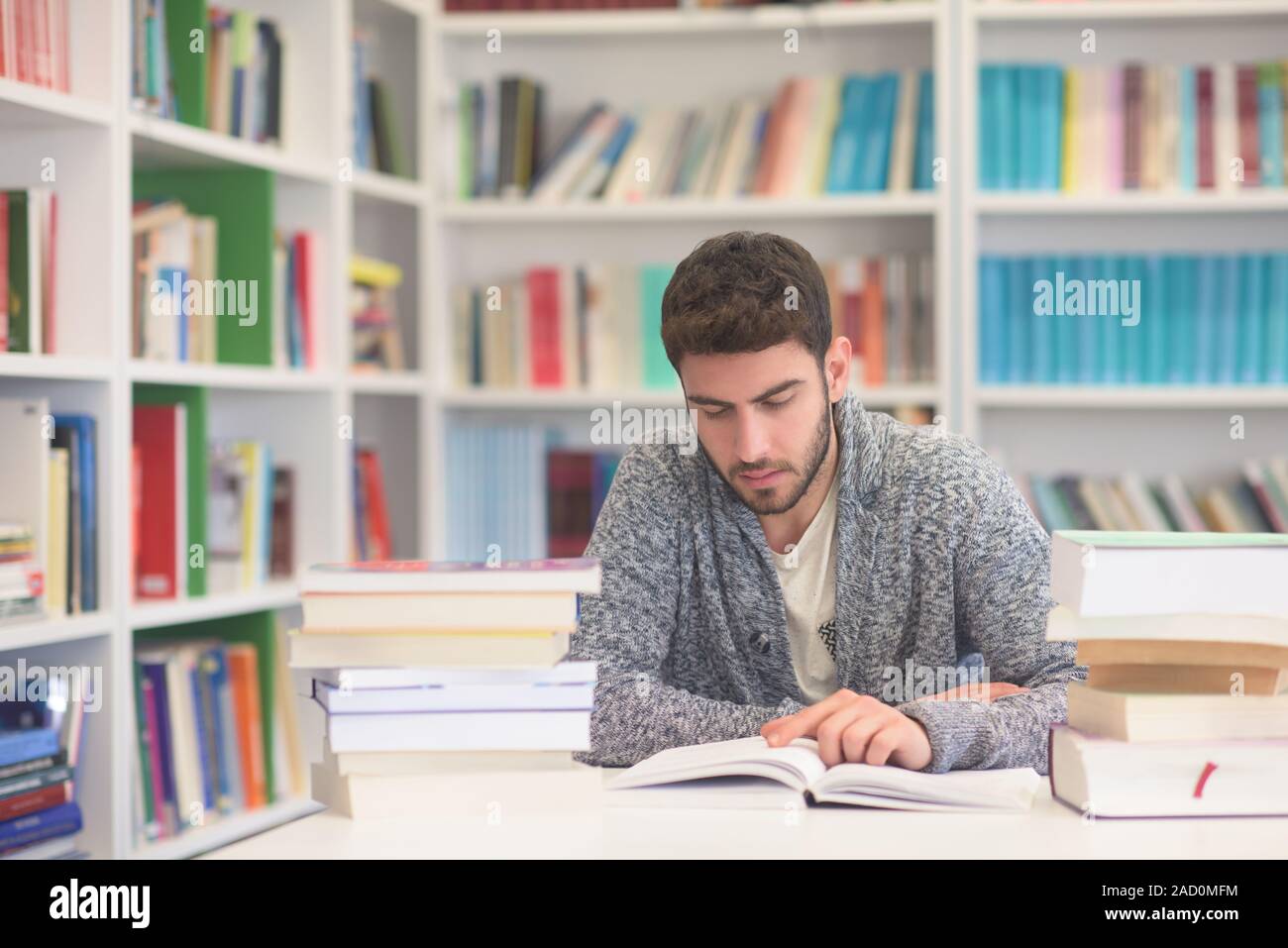portrait of student while reading book in school library Stock Photo ...