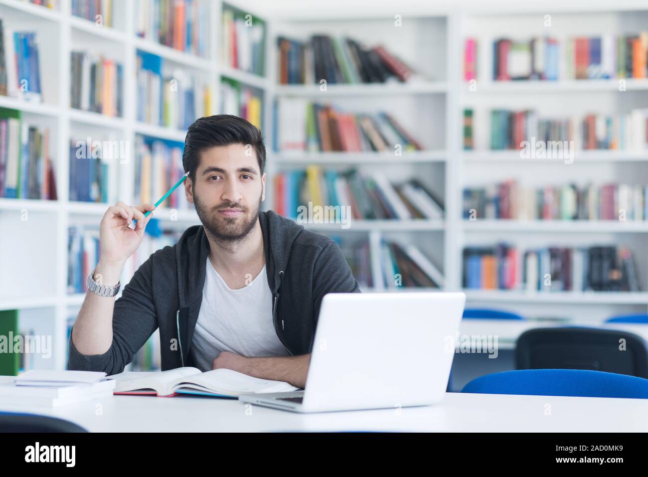 student in school library using laptop for research Stock Photo - Alamy