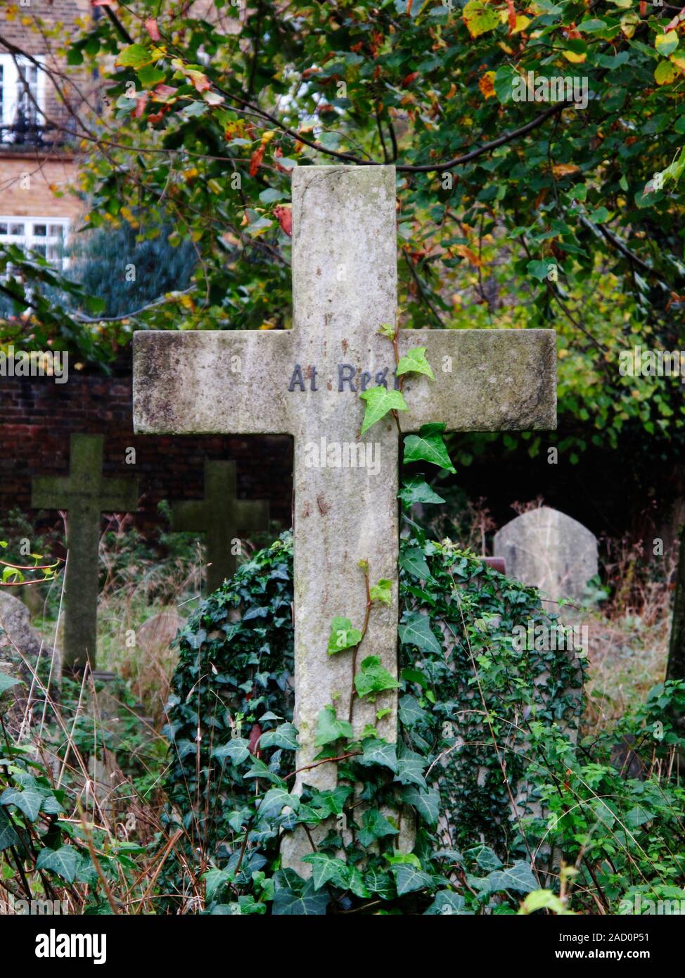 Stone cross in an urban cemetery. Photographed in Brompton Cemetery ...