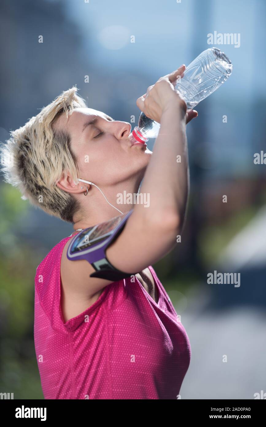 woman drinking water after jogging Stock Photo - Alamy