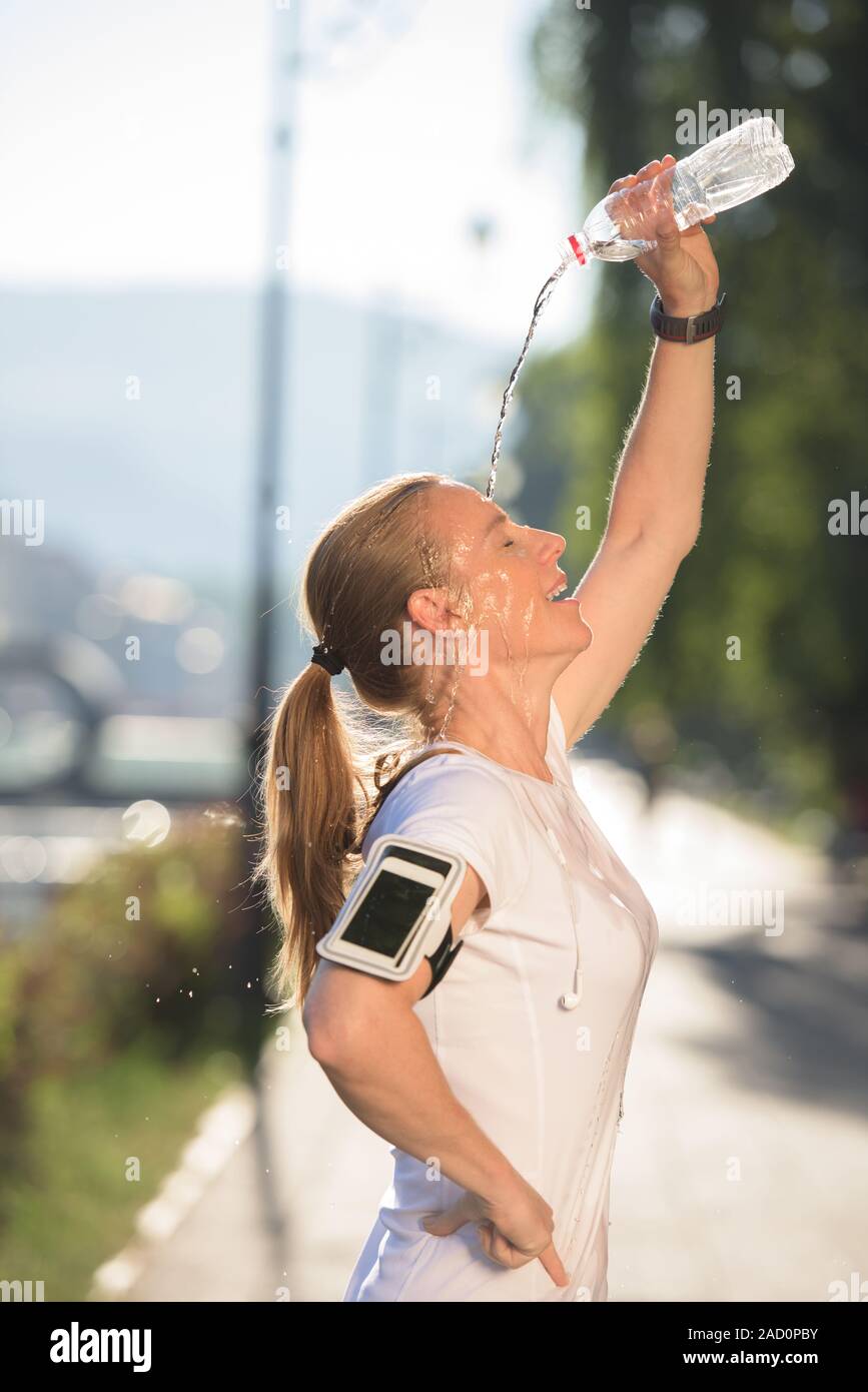 woman drinking water after jogging Stock Photo - Alamy
