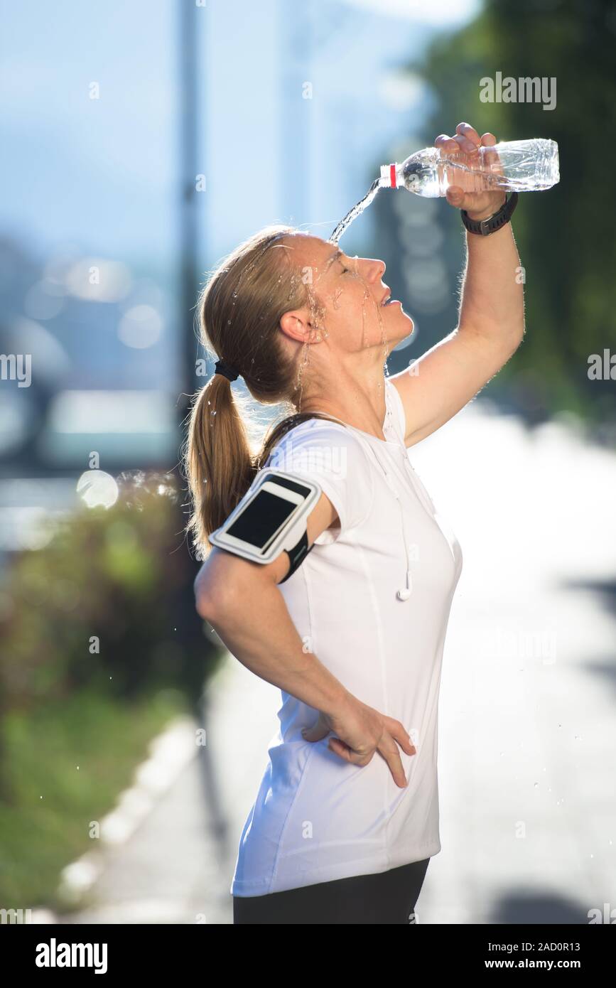 woman drinking water after jogging Stock Photo - Alamy