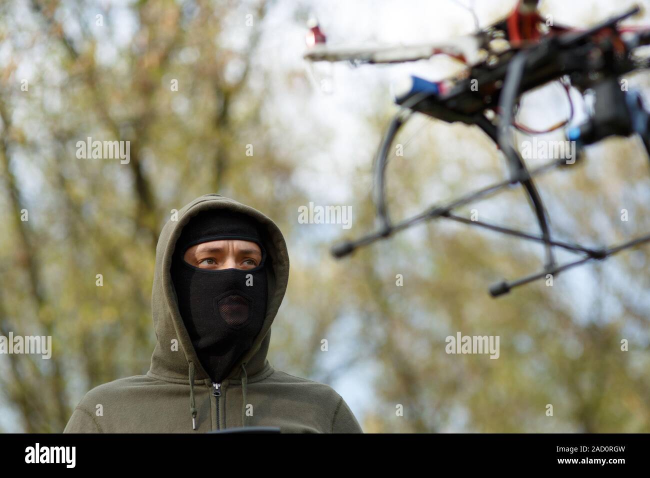 Man in mask operating a drone with remote control Stock Photo - Alamy