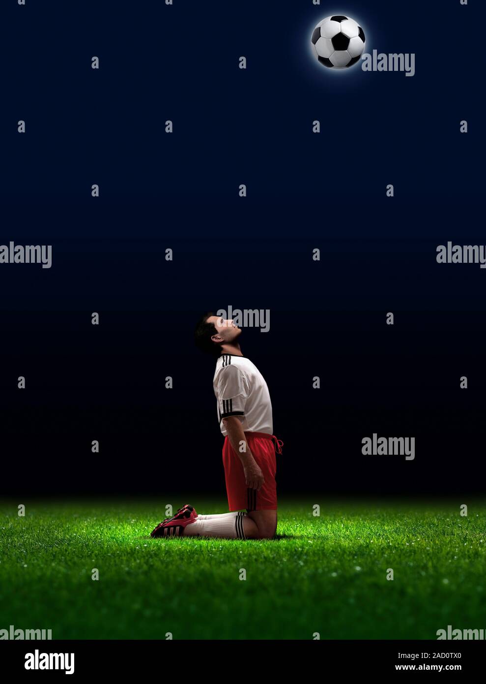 Football worship. Conceptual image of a footballer kneeling in prayer ...