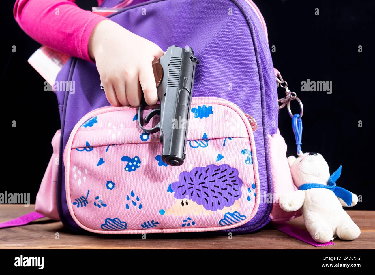 Girl hides a gun in a school backpack. Covert carrying weapons for ...