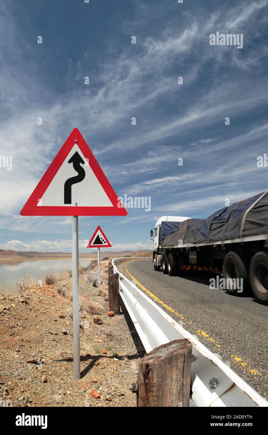 Road warning signs. Sign warning of sharp bends and rockfalls on a road ...