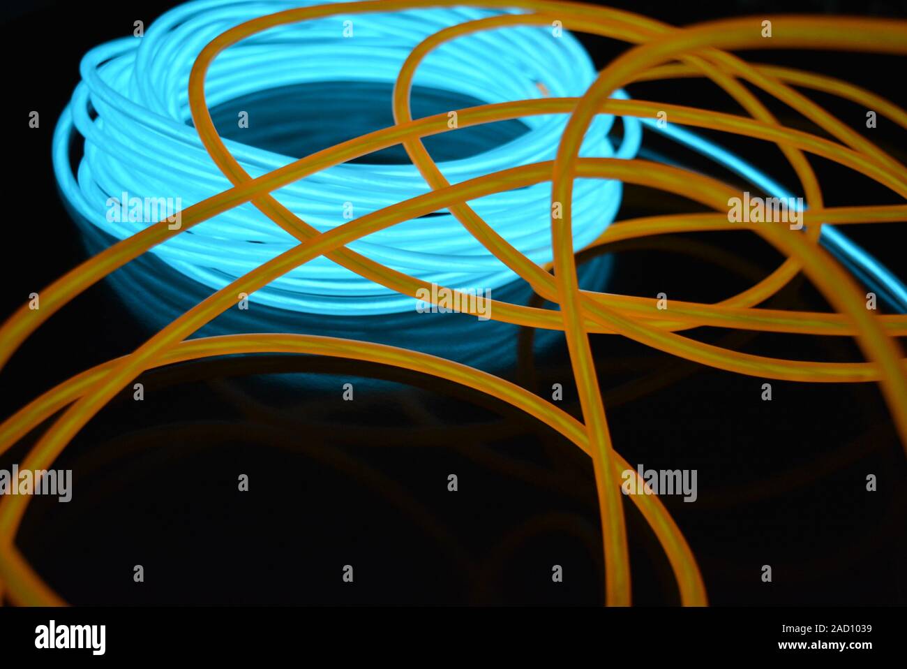 A bright coil of turquoise, sky blue luminous wire with chaotic wires ...