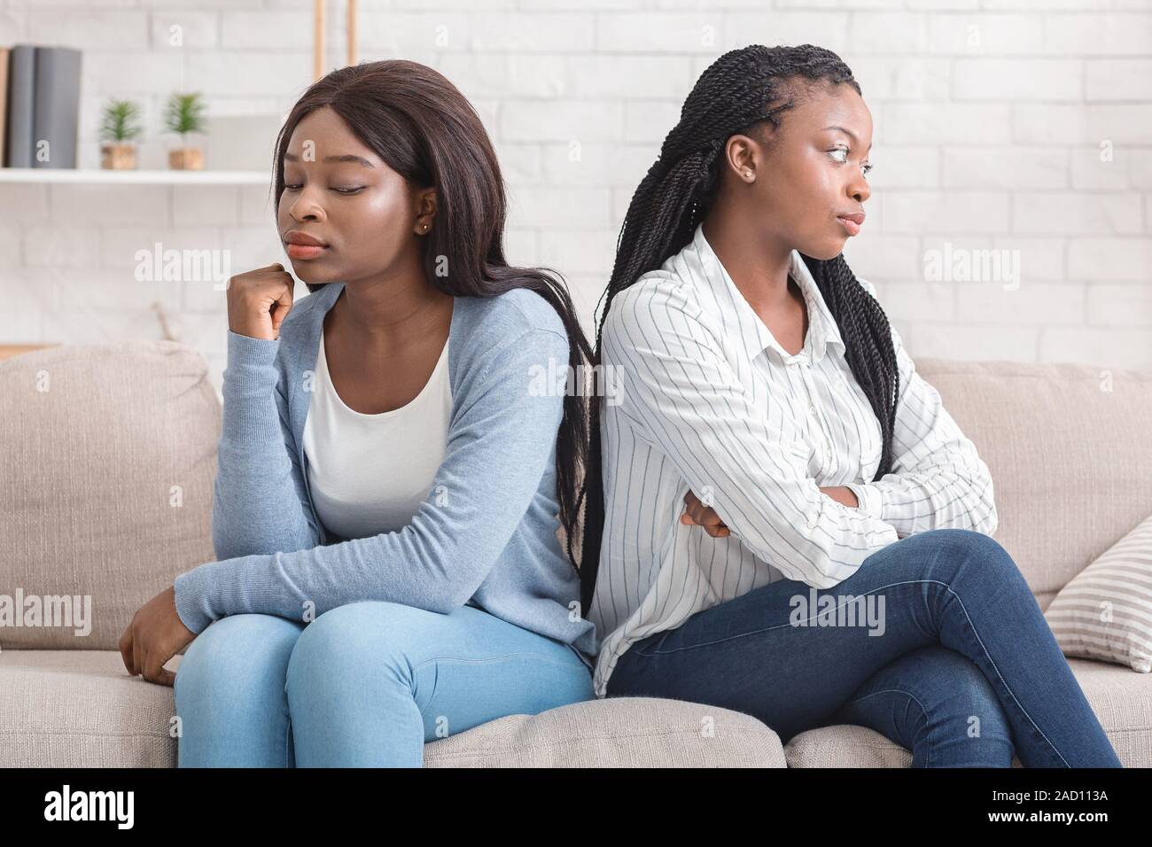 Offended girlfriends sitting back to back, ignoring each other after ...