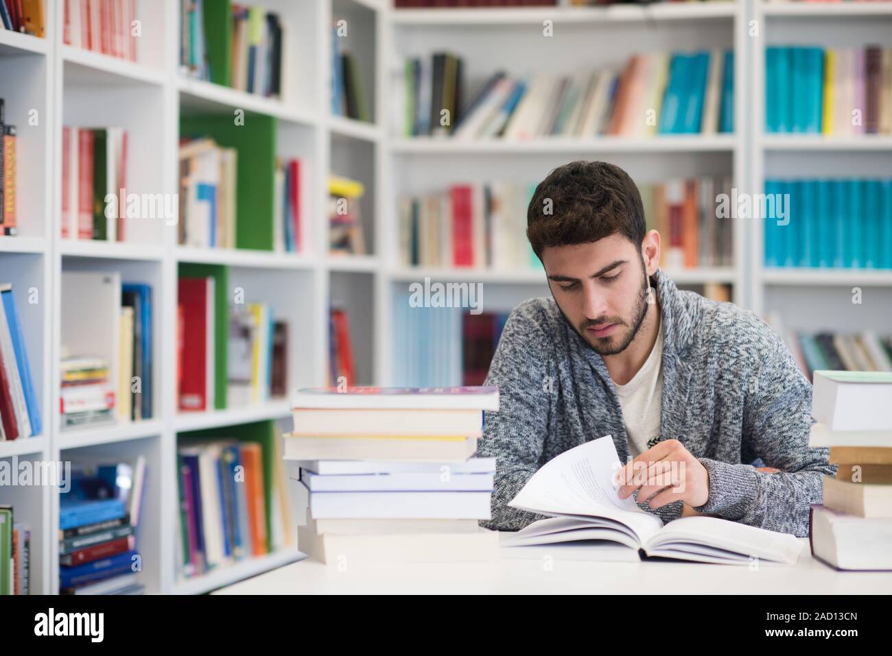 portrait of student while reading book in school library Stock Photo ...