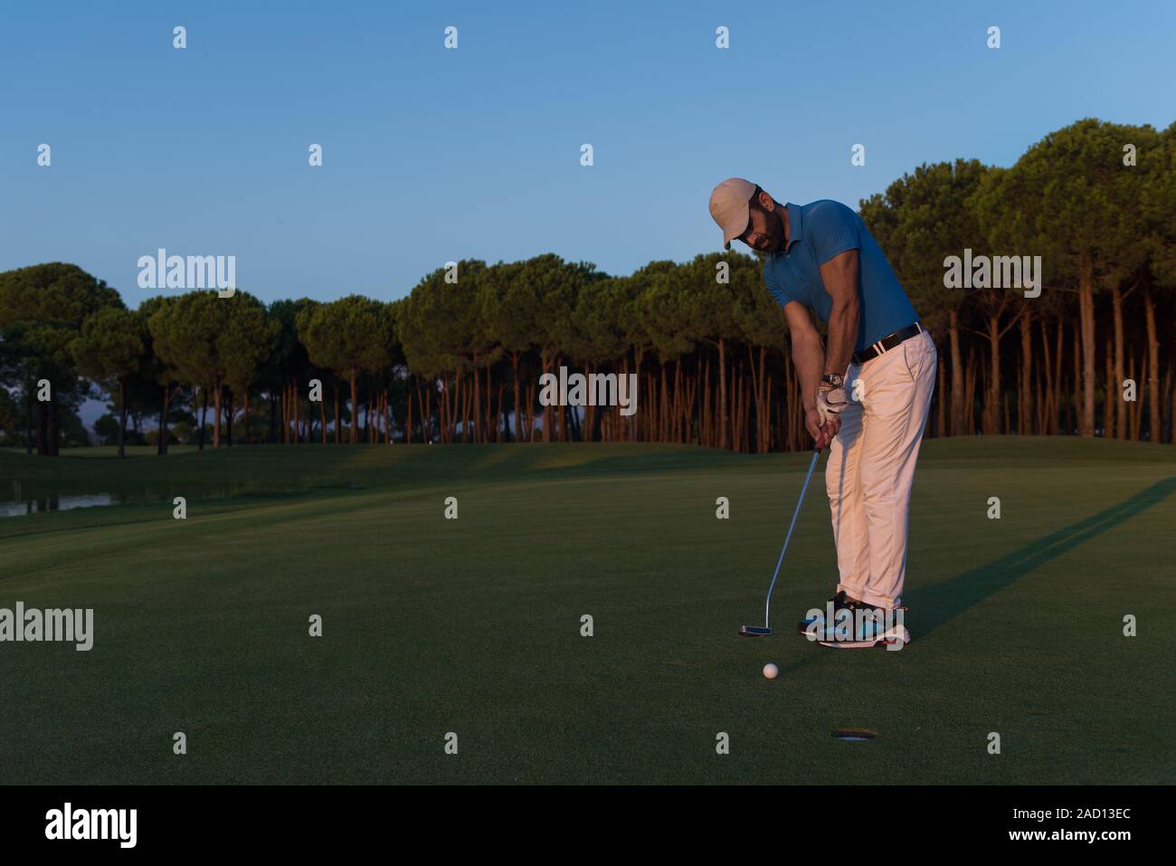 golfer hitting shot at golf course Stock Photo - Alamy