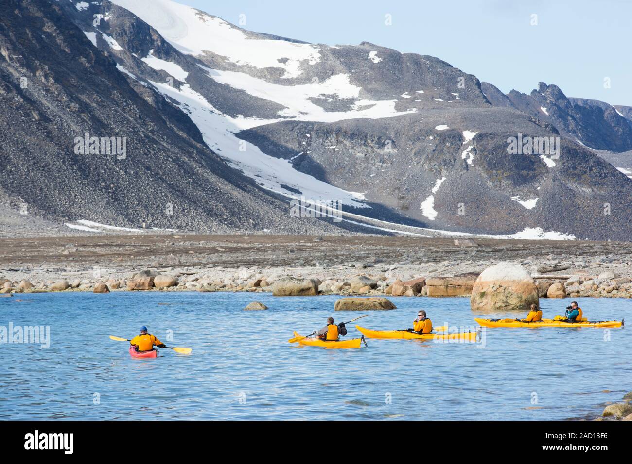 An expedition cruise tour using sea kayaks off a beach in northern ...