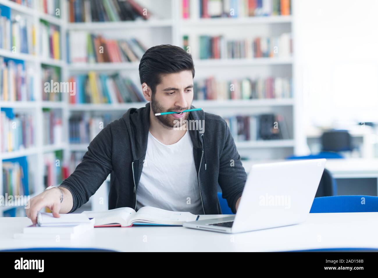 student in school library using laptop for research Stock Photo - Alamy