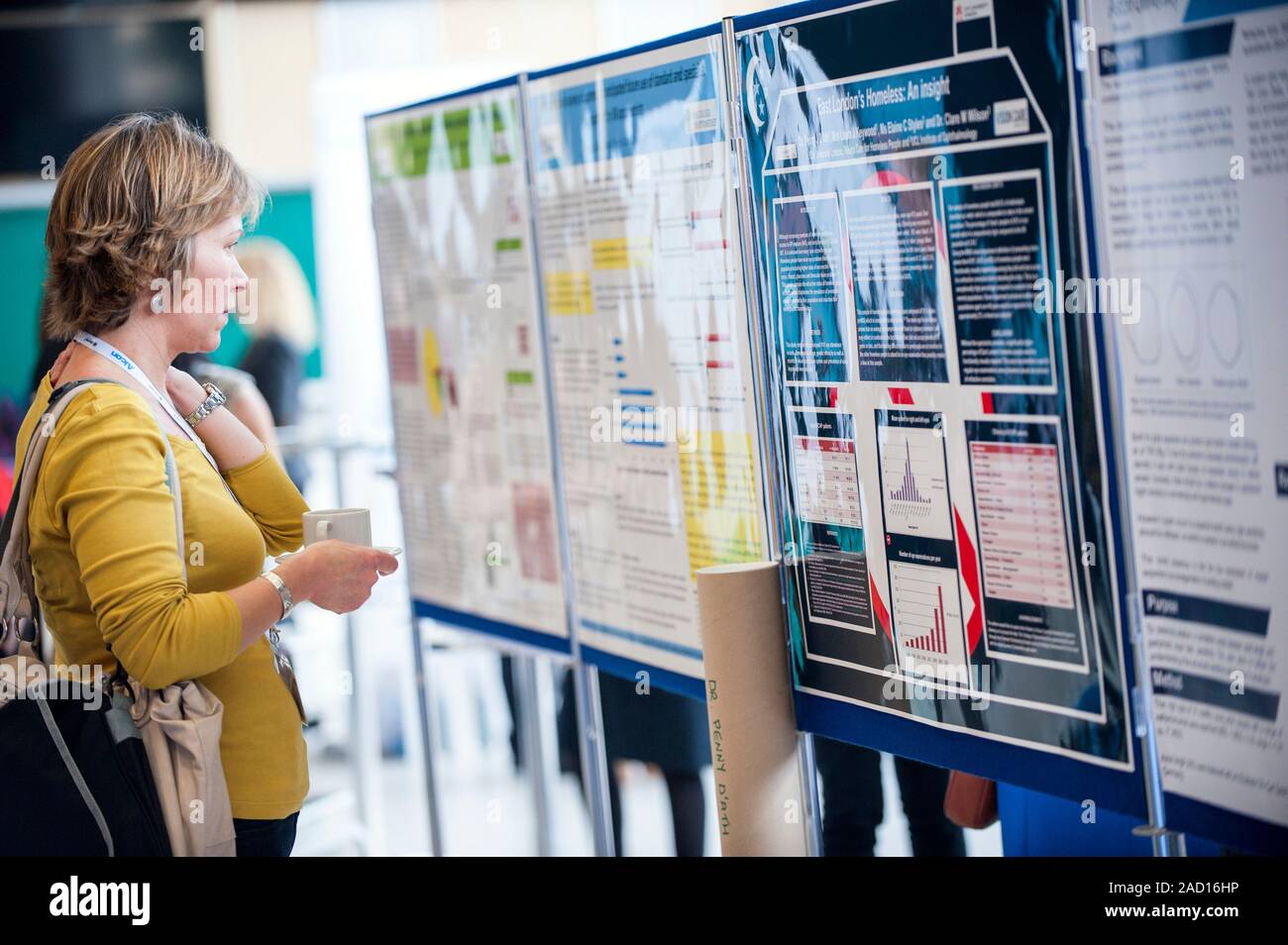 Optometry conference posters. Delegate at an information stand with ...