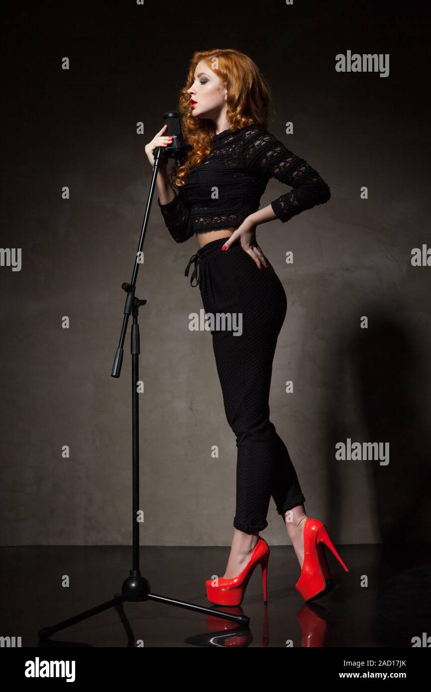 Portrait of beautiful singer in red heels and black clothes Stock Photo ...