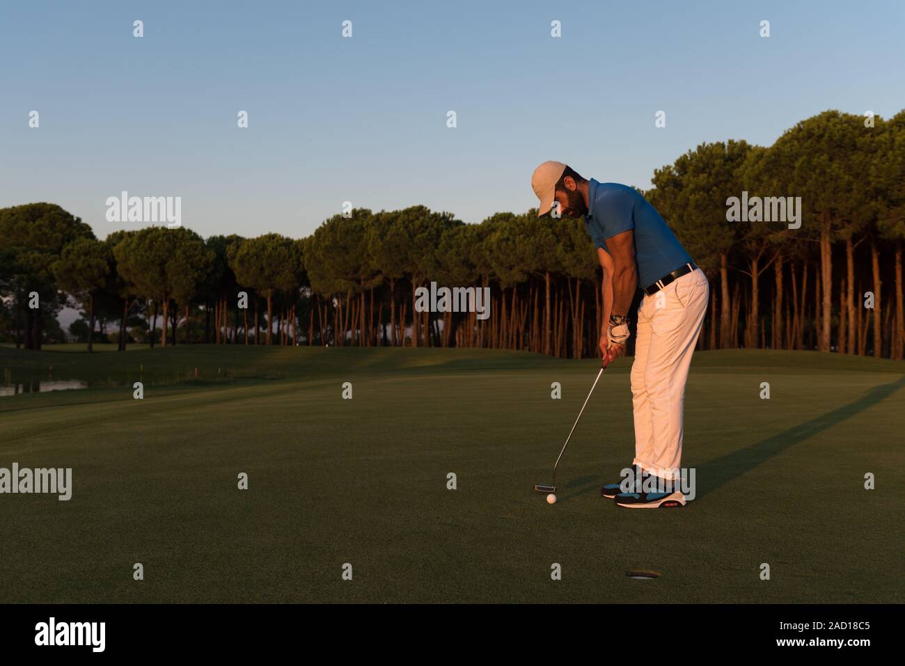golfer hitting shot at golf course Stock Photo - Alamy
