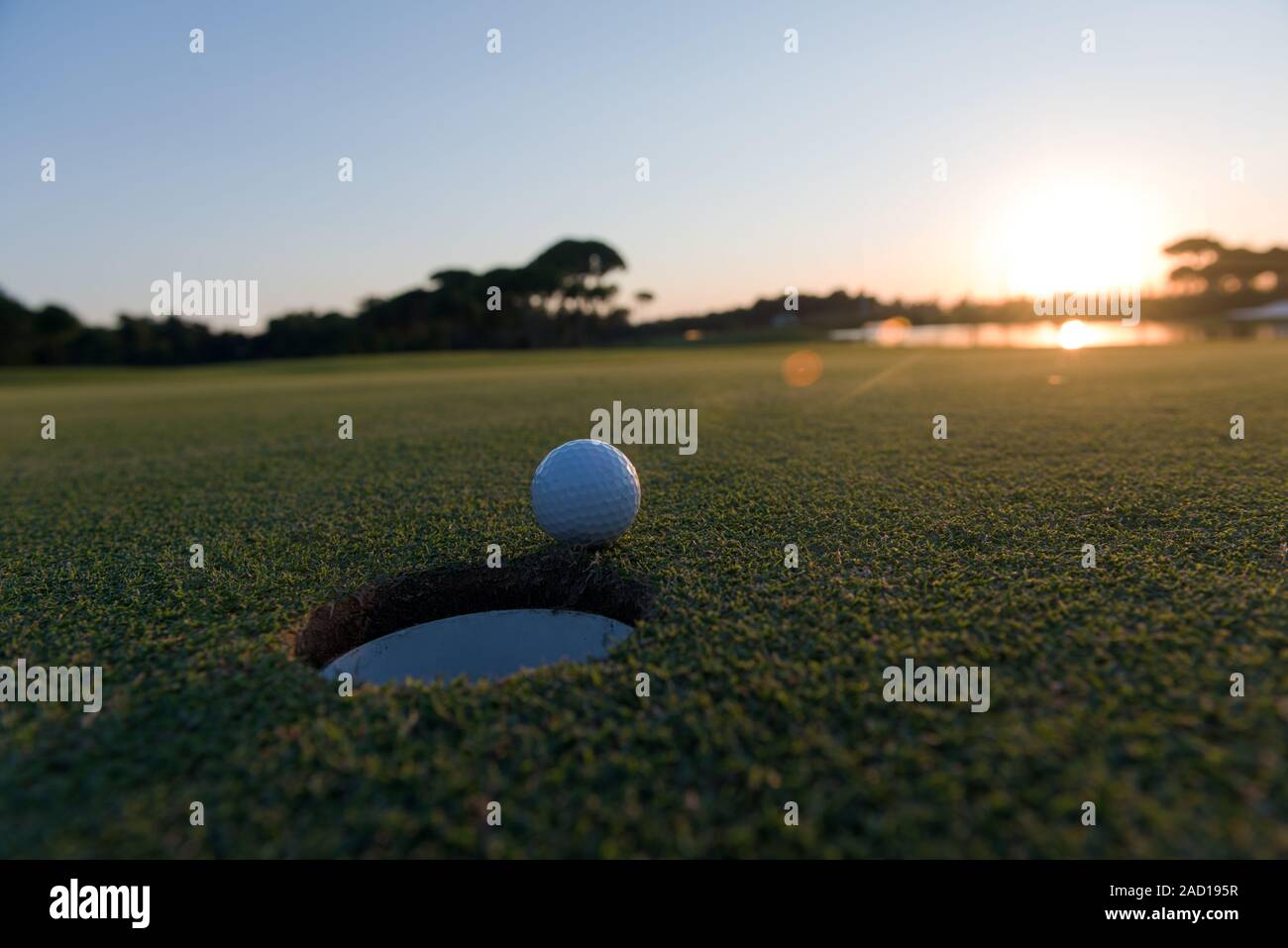 golf ball on edge of the hole Stock Photo - Alamy